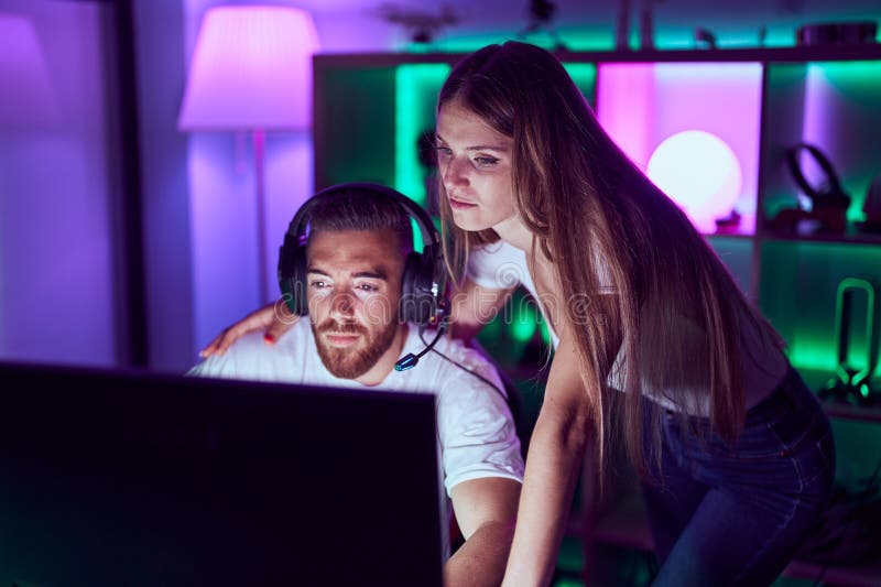 Young Couple Playing Video Games Relaxed with Serious Expression on ...