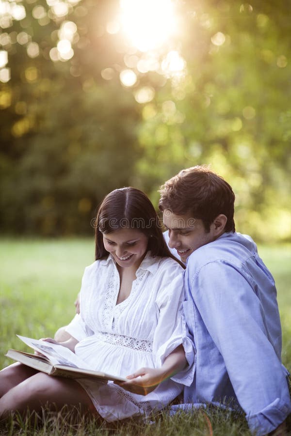 Young Couple Reading a Book in a Park Stock Image - Image of women ...