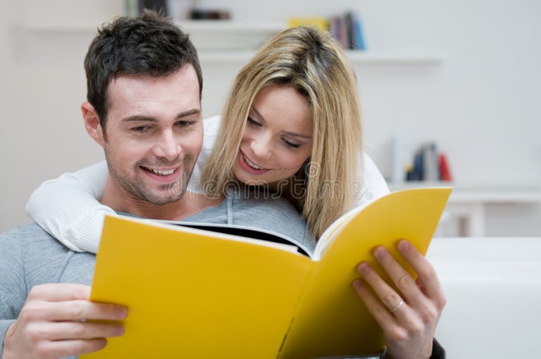 Young Couple Reading Magazine Stock Image - Image of embrace, news ...