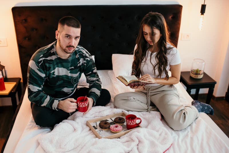 Young Couple Relaxing on a Bed with Warm Drinks Stock Photo - Image of ...
