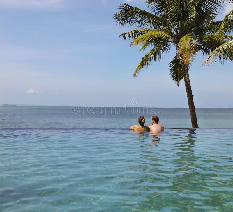 Young Couple Relaxing in Infinity Pool Under Coco Palms Stock Photo ...