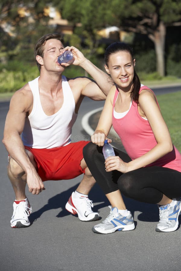 Young Couple Resting and Drinking Water after Exercise Stock Image ...