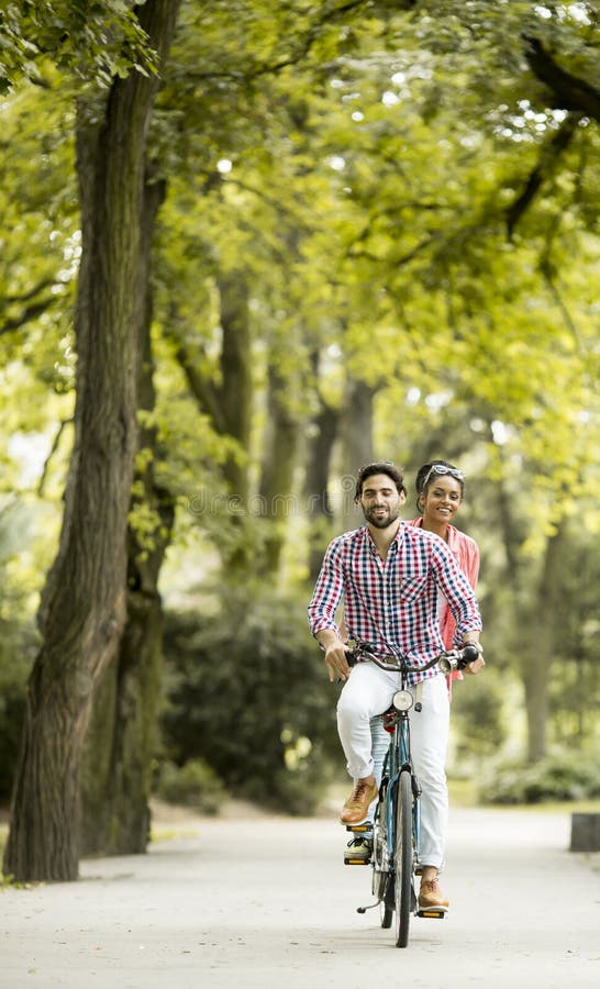 Young Couple Riding on Bicycle Stock Image - Image of park, beautiful ...