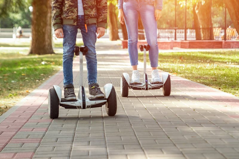A Young Couple Riding a Hoverboard in a Park, Self-balancing Scooter ...