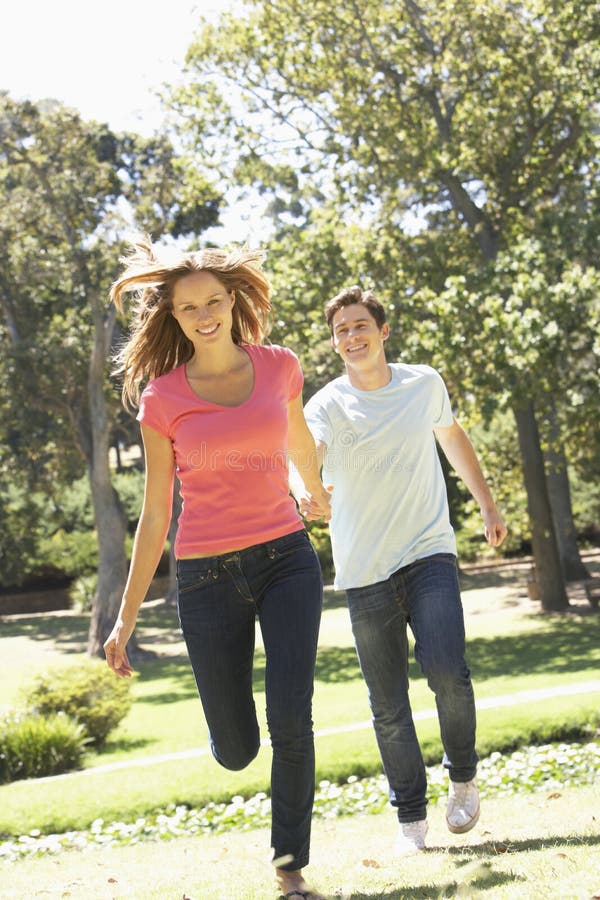 Young Couple Running through Park Stock Photo - Image of vertical, park ...