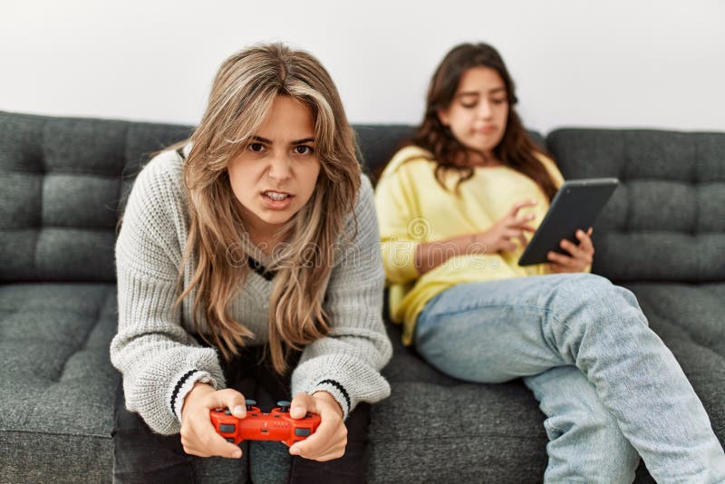 Young Couple with Serious Expression Playing Video Game and Using ...