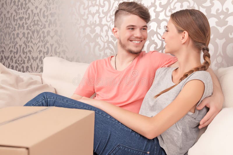 Young Couple Siting on Sofa Stock Photo - Image of settee, family: 57437910