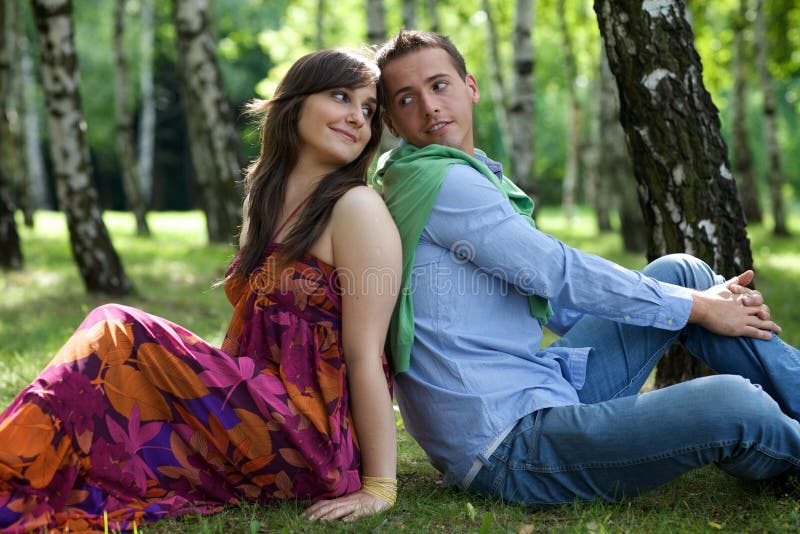 Young Couple Sitting Back To Back in Park Stock Image - Image of people ...