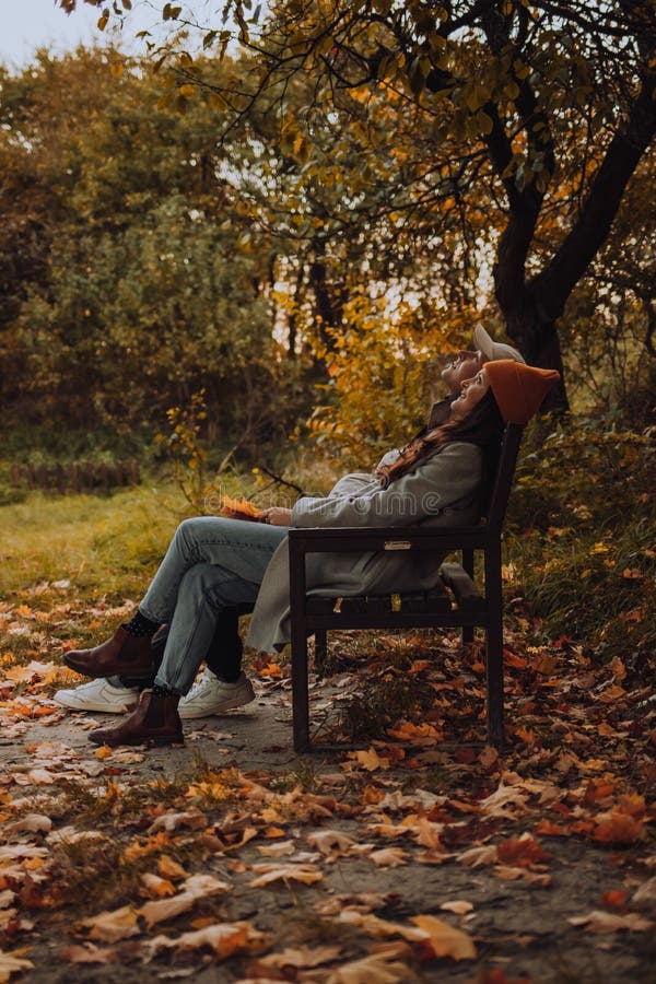 Young Couple Sitting on Bench and Looking Up in Fall Season Stock Image ...