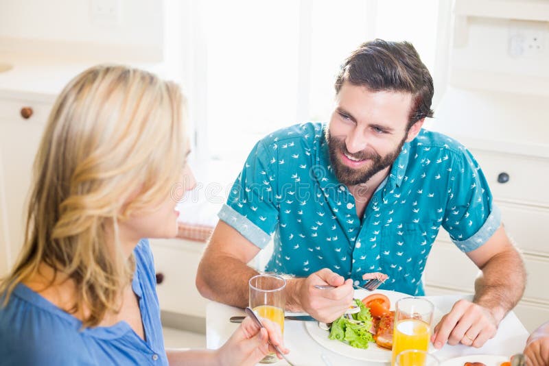 Young Couple Sitting at Dining Table Talking Stock Image - Image of ...