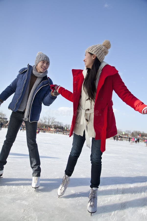Young Couple Skating at Ice Rink, Holding Hands Stock Photo - Image of ...
