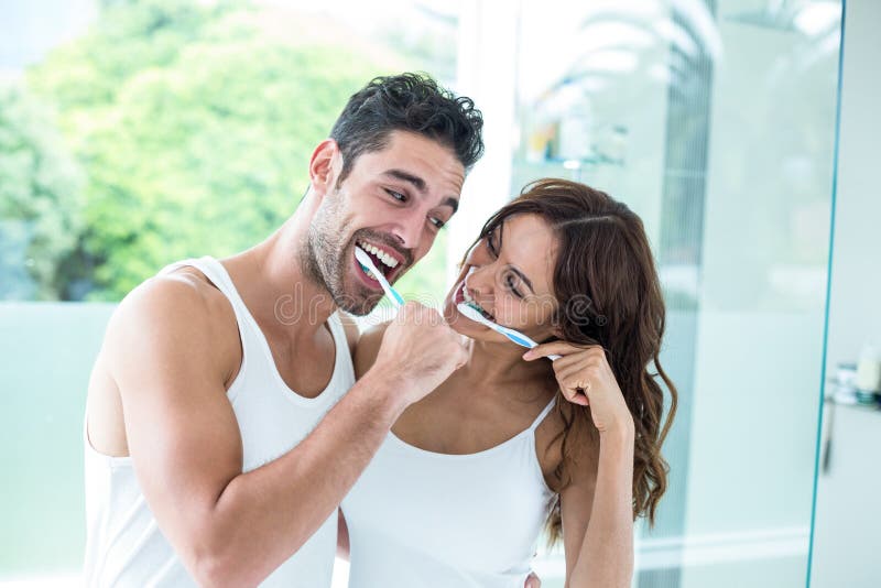 Young Couple Smiling while Brushing Teeth Stock Photo - Image of ...