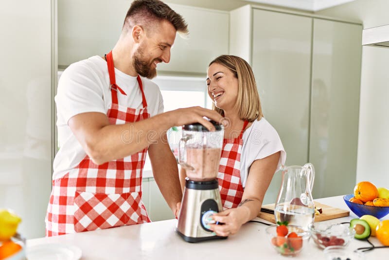 Young Couple Smiling Confident Making Smoothie Using Blender at Kitchen ...