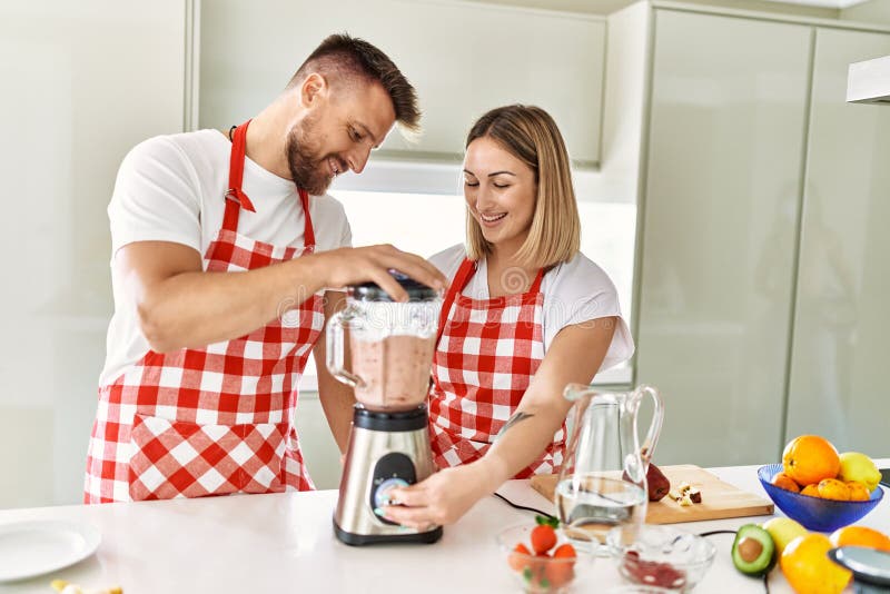 Young Couple Smiling Confident Making Smoothie Using Blender at Kitchen ...