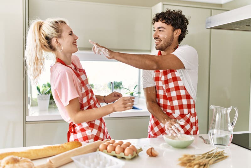 Young Couple Smiling Happy Playing with Flour at Kitchen Stock Image ...