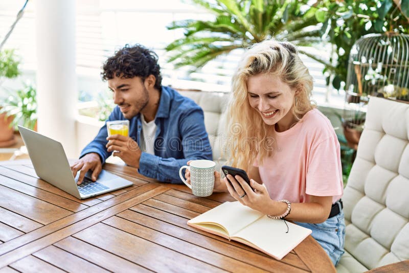 Young Couple Smiling Happy Using Laptop and Smartphone Sitting on the ...