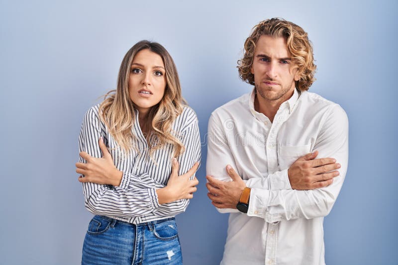 Young Couple Standing Over Blue Background Shaking and Freezing for ...