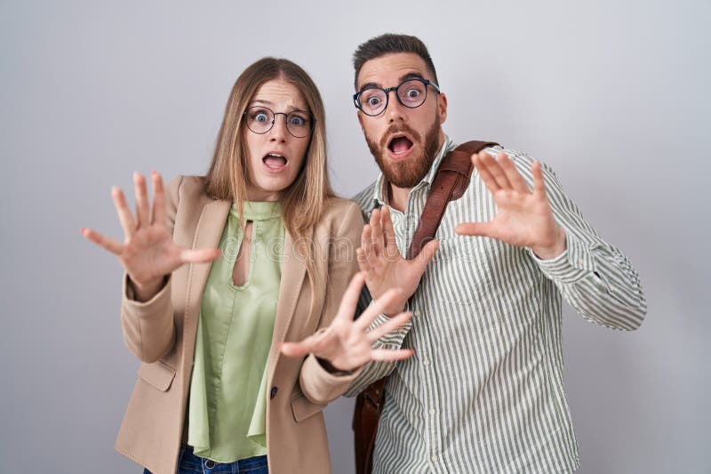Young Couple Standing Over White Background Afraid and Terrified with ...