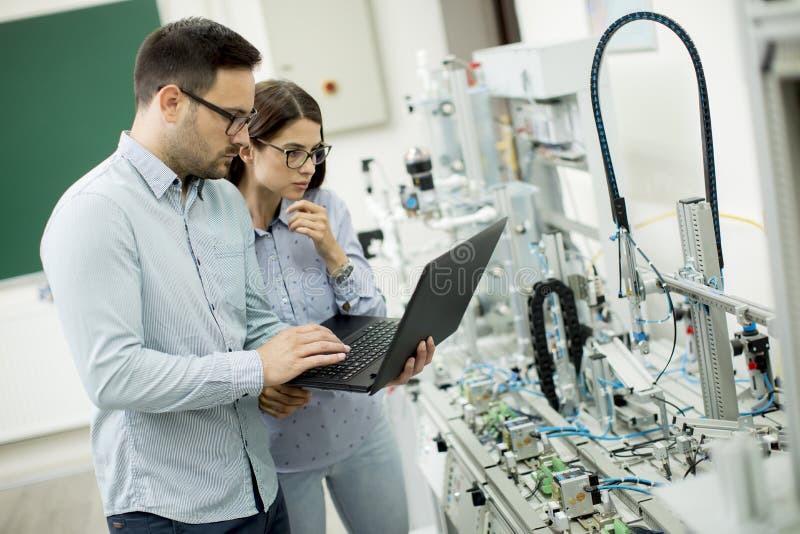 Young Couple of Students with Laptop at Robotics Lab Stock Photo ...