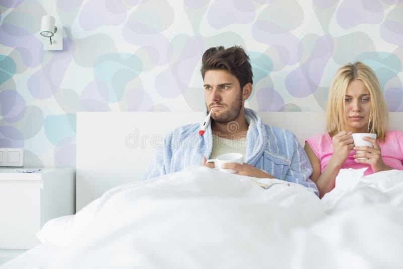 Young Couple Suffering from Cold while Relaxing in Bed at Home Stock ...