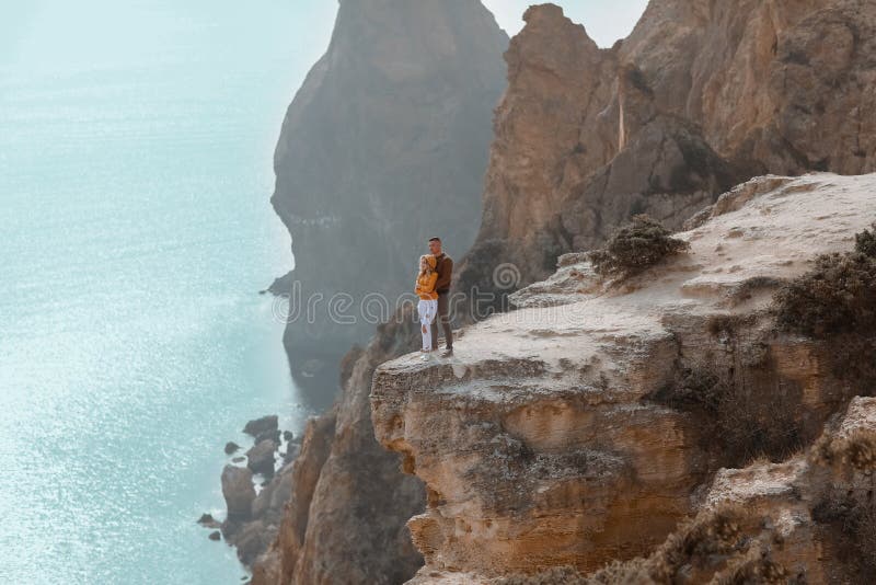 A Young Couple of Sweethearts Cuddle on Top of a Stone Mountain with a ...