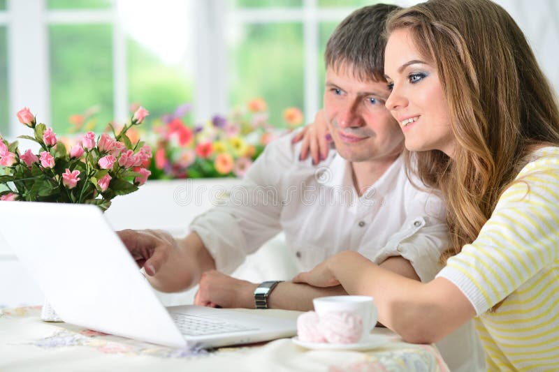 Young Couple at Table and Using Laptop Stock Photo - Image of style ...
