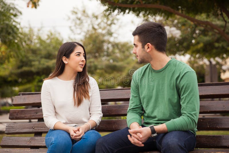 Young Couple Talking at a Park Stock Photo - Image of casual, outdoor ...