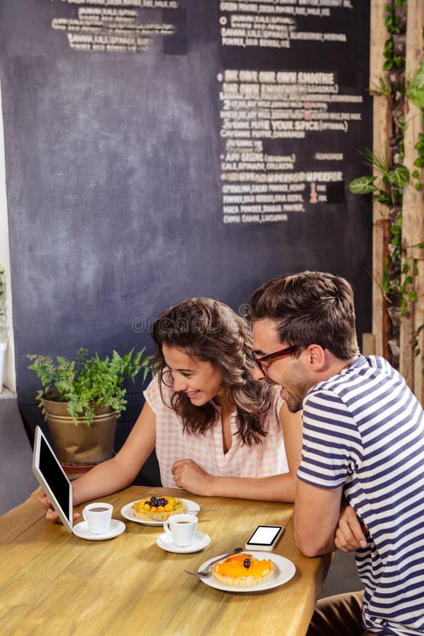 Young Couple Using Digital Tablet in Cafeteria Stock Image - Image of ...