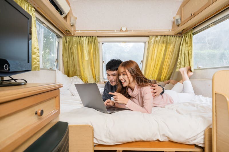 Couple Using Laptop Computer on Bed of a Camper RV Van Motorhome Stock ...