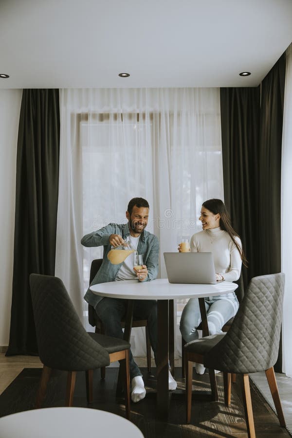 Young Couple Using Laptop Computer on the Table in the Living Room ...