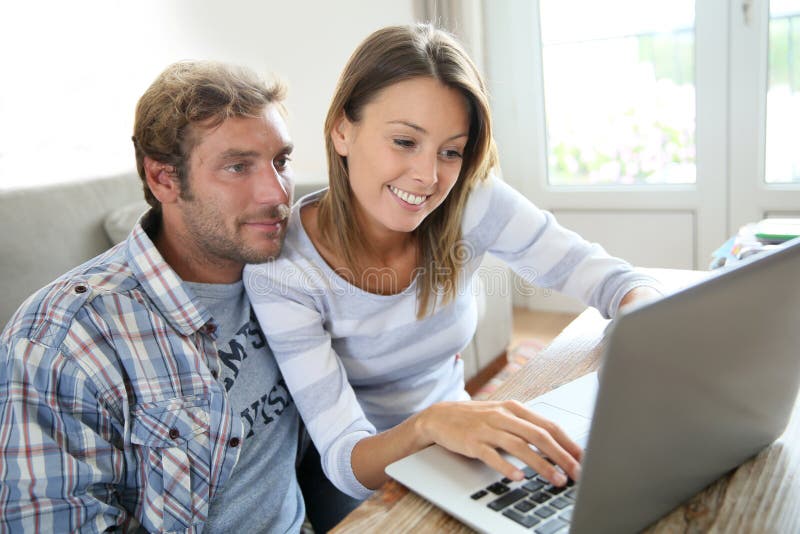 Young Couple Using Laptop at Home Stock Image - Image of young ...