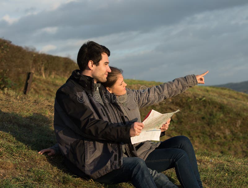 Young couple using map stock image. Image of fingerpost - 67558975