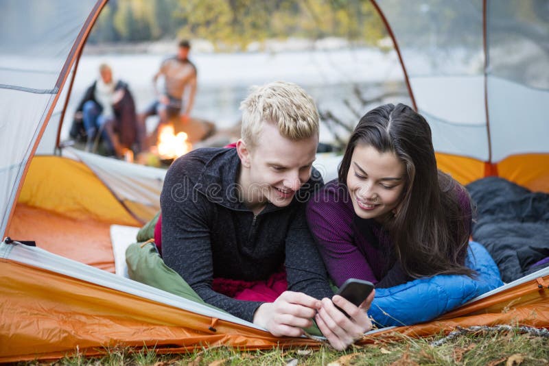 Young Couple Using Mobile Phone in Tent Stock Photo - Image of healthy ...