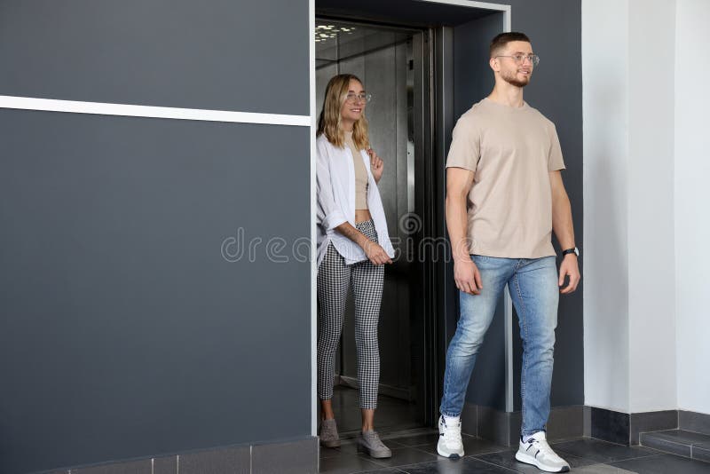 Young Couple Walking Out of Modern Elevator Stock Photo - Image of ...