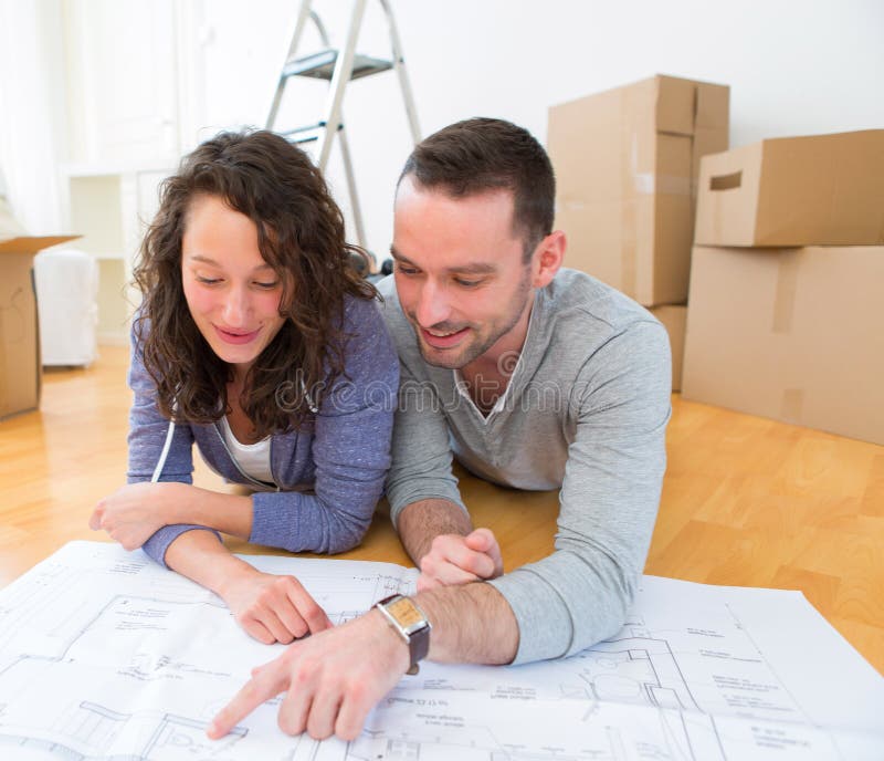 Young Couple Watching Plans in Their New Flat Stock Photo - Image of ...