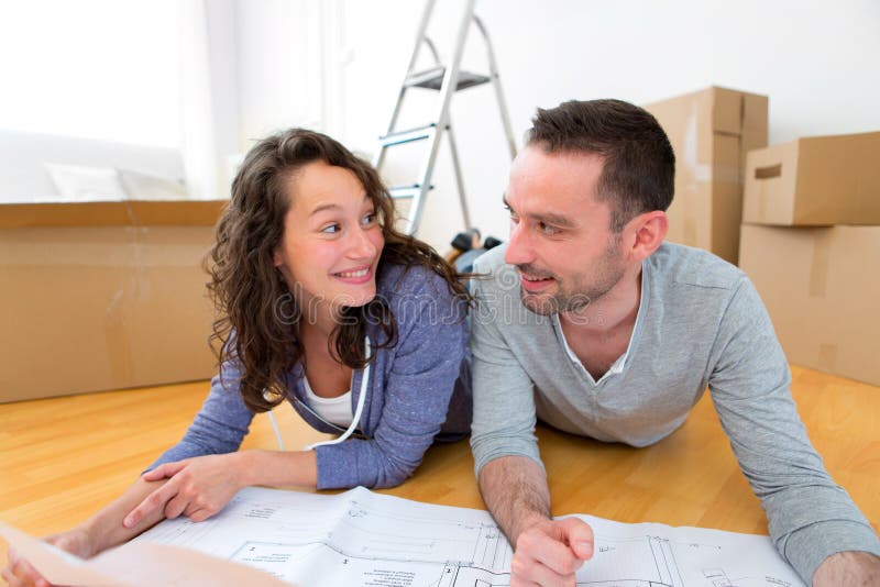 Young Couple Watching Plans in Their New Flat Stock Image - Image of ...