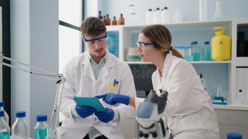 Young Couple Wearing Scientist Uniform Using Touchpad at Laboratory ...