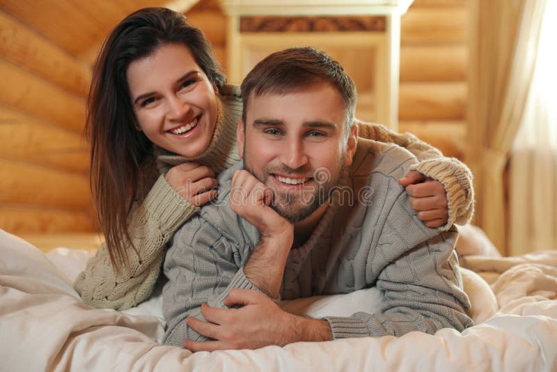 Young Couple Wearing Warm Sweaters on Bed at Home Stock Photo - Image ...