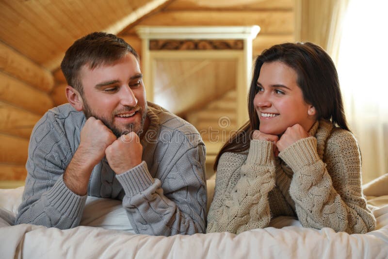 Young Couple Wearing Warm Sweaters on Bed at Home Stock Photo - Image ...