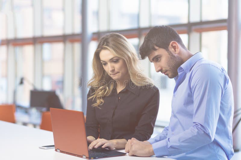 Young Couple Working Together on a Laptop in the Office. Teamwork ...