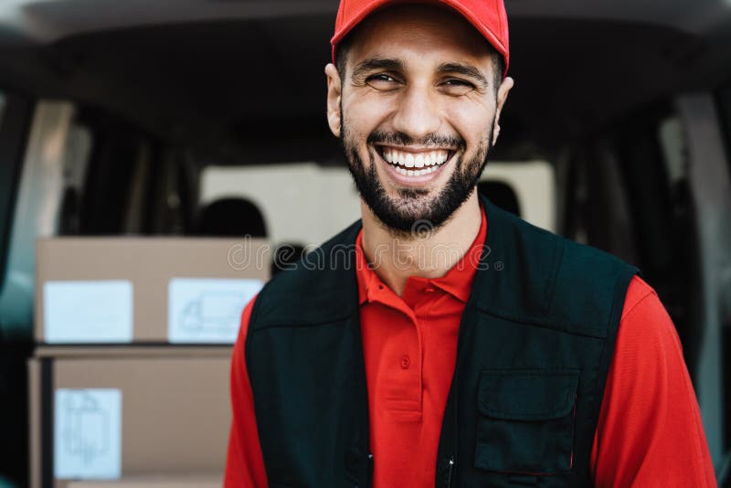 Young Courier Delivery Man Smiling into the Camera while Standing in ...
