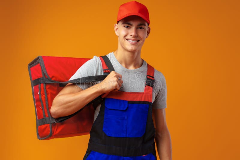 Young Courier in Uniform with Thermo Bag on Yellow Background Stock ...