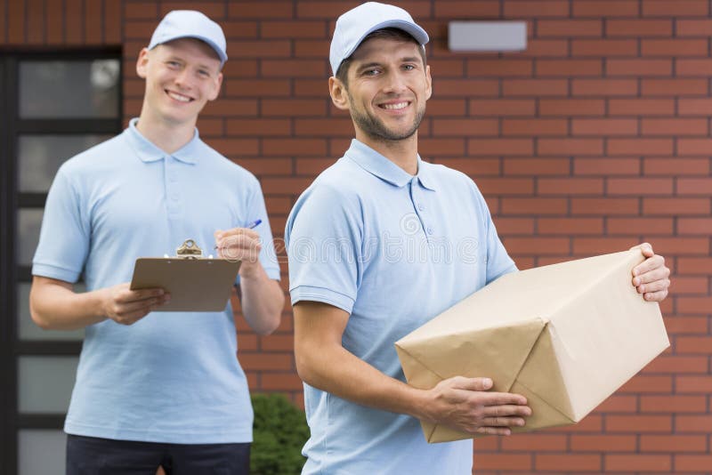 Friendly Couriers in Blue Uniforms and Woman Signing Receipt of Package ...