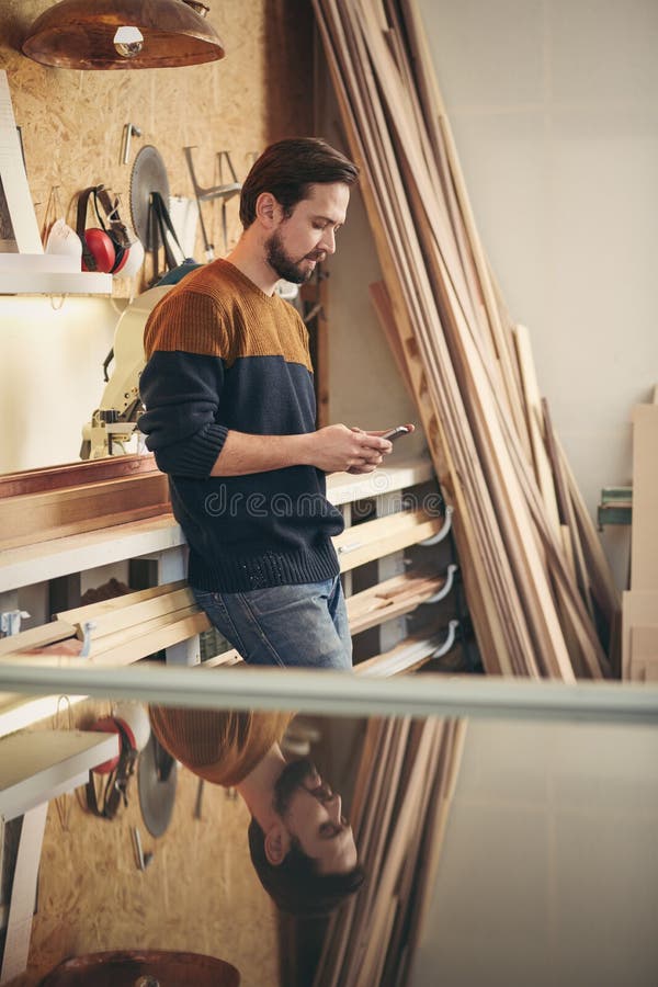 Young Craftsman Using Phone in His Workshop Stock Photo - Image of male ...