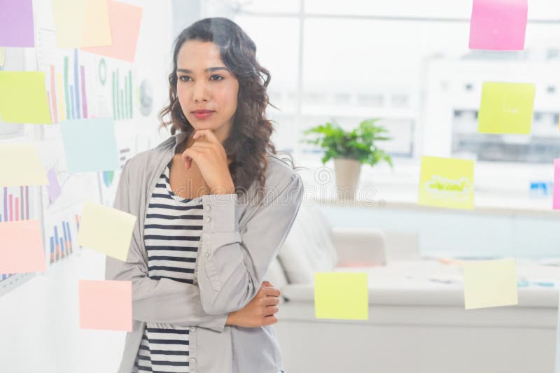 Glass Board Displaying Pastel Sticky Notes and Printed Charts in Modern ...