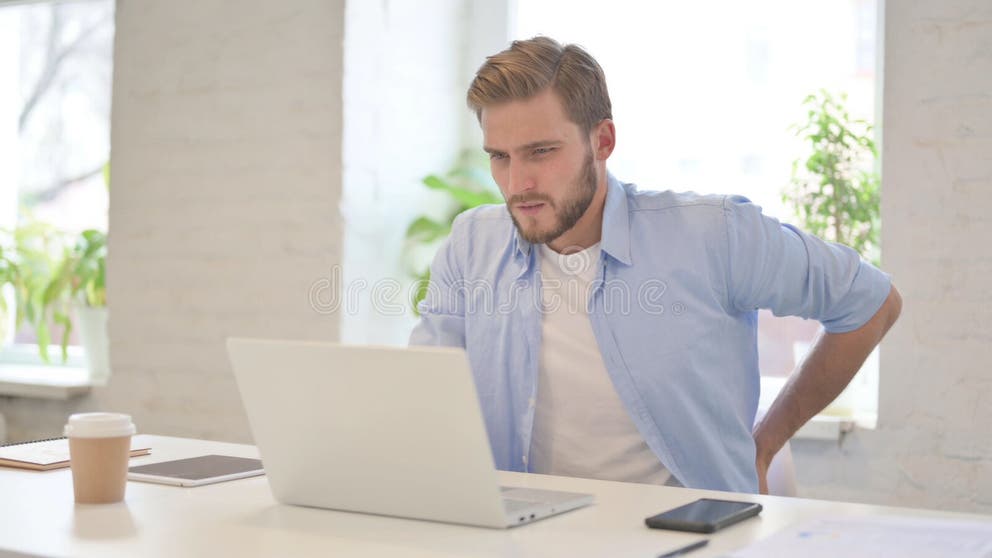 Young Man Having Back Pain in Modern Office Stock Photo - Image of ...