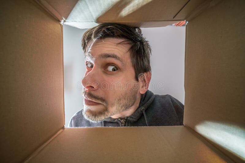 Young Curious and Suspicious Man is Looking Inside Cardboard Box. Stock ...