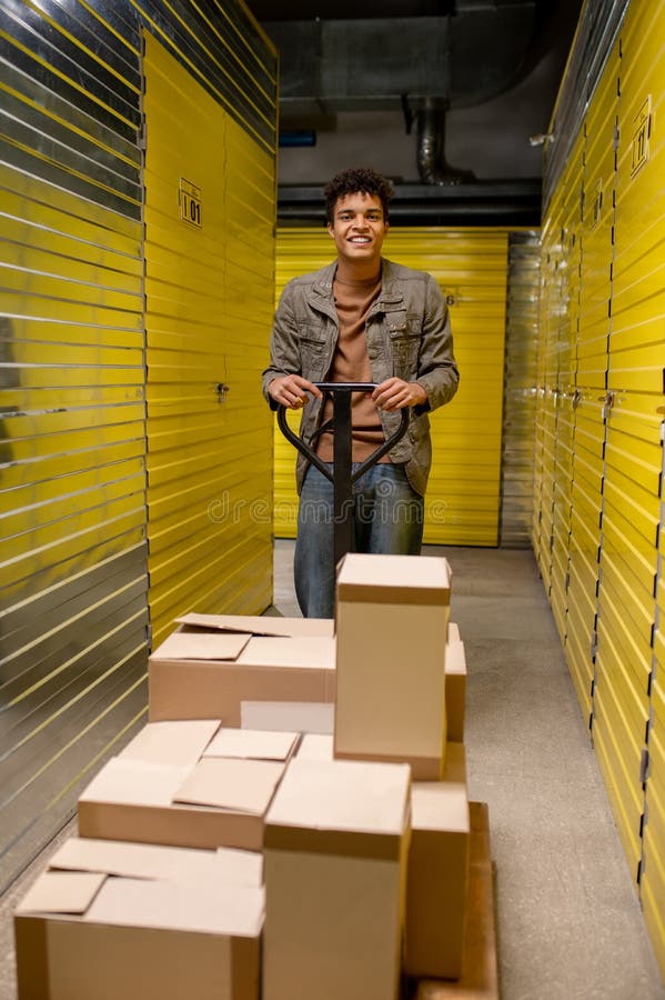 Young Curly-haired Man in a Warehouse with Many Boxes Stock Image ...