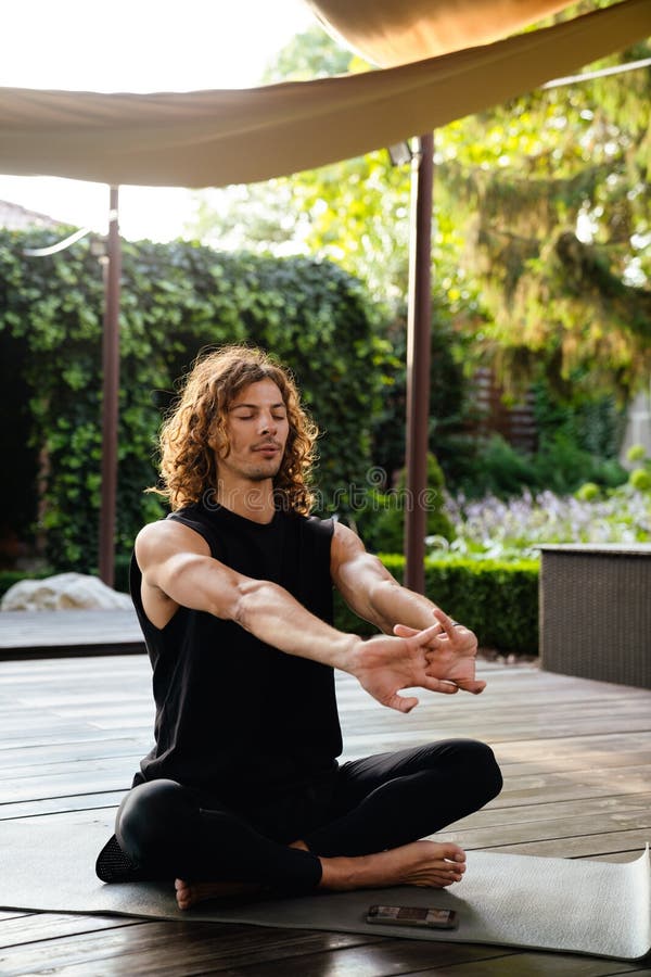 Young Curly Man Doing Workout on Exercise Mat in Yoga Studio Outdoors ...