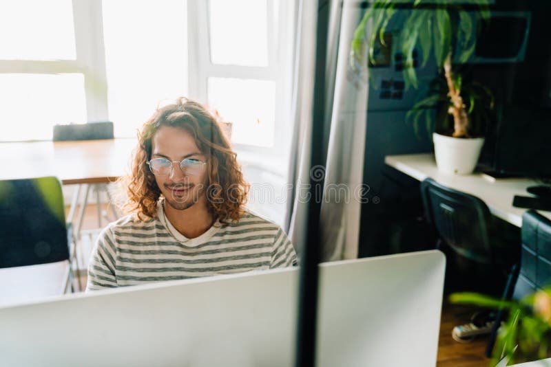 Young Curly Man Using Desktop Computer while Sitting in Office Stock ...